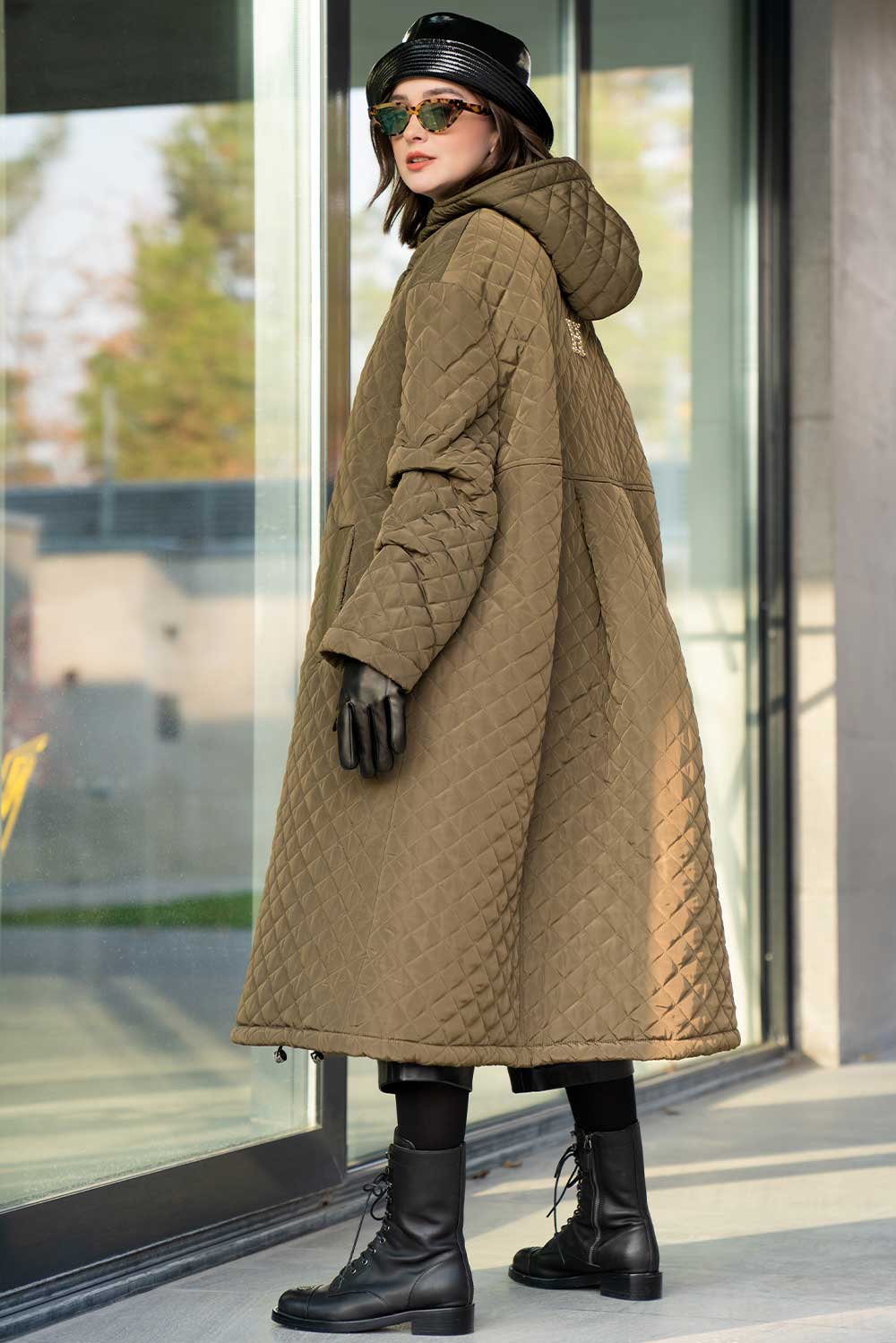 Mid length moss green rain jacket with triangular layers on front and ...